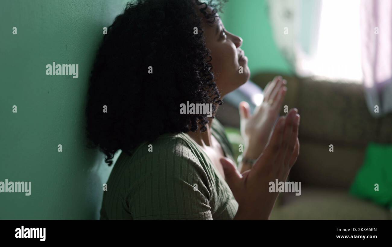 One Evangelical young black woman in praying to GOD raising hands in ...