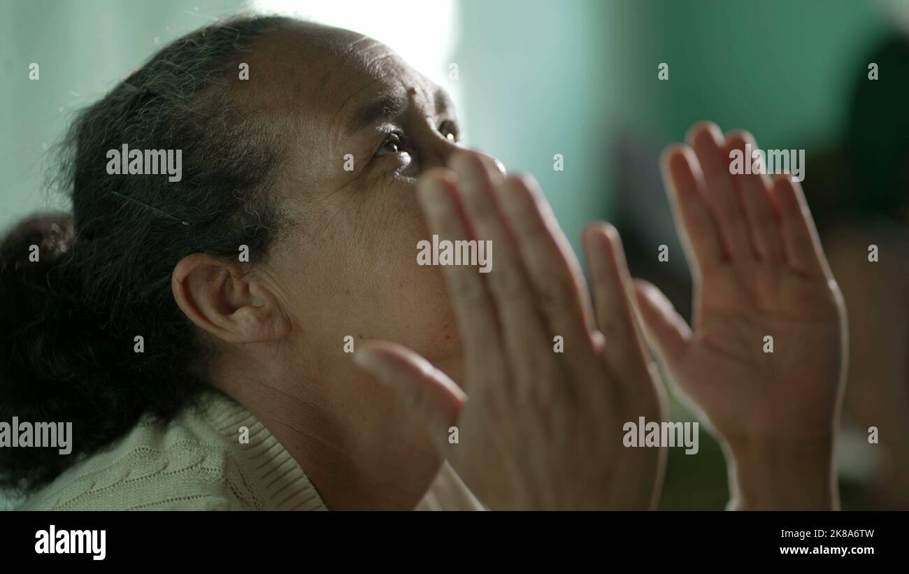 Religious Hispanic older woman praying to God. Spiritual Brazilian ...