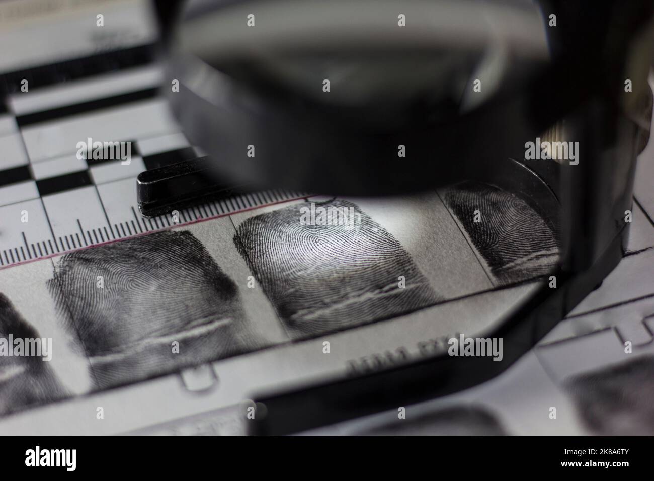 Magnifying glass with a fingerprint card close-up Stock Photo - Alamy