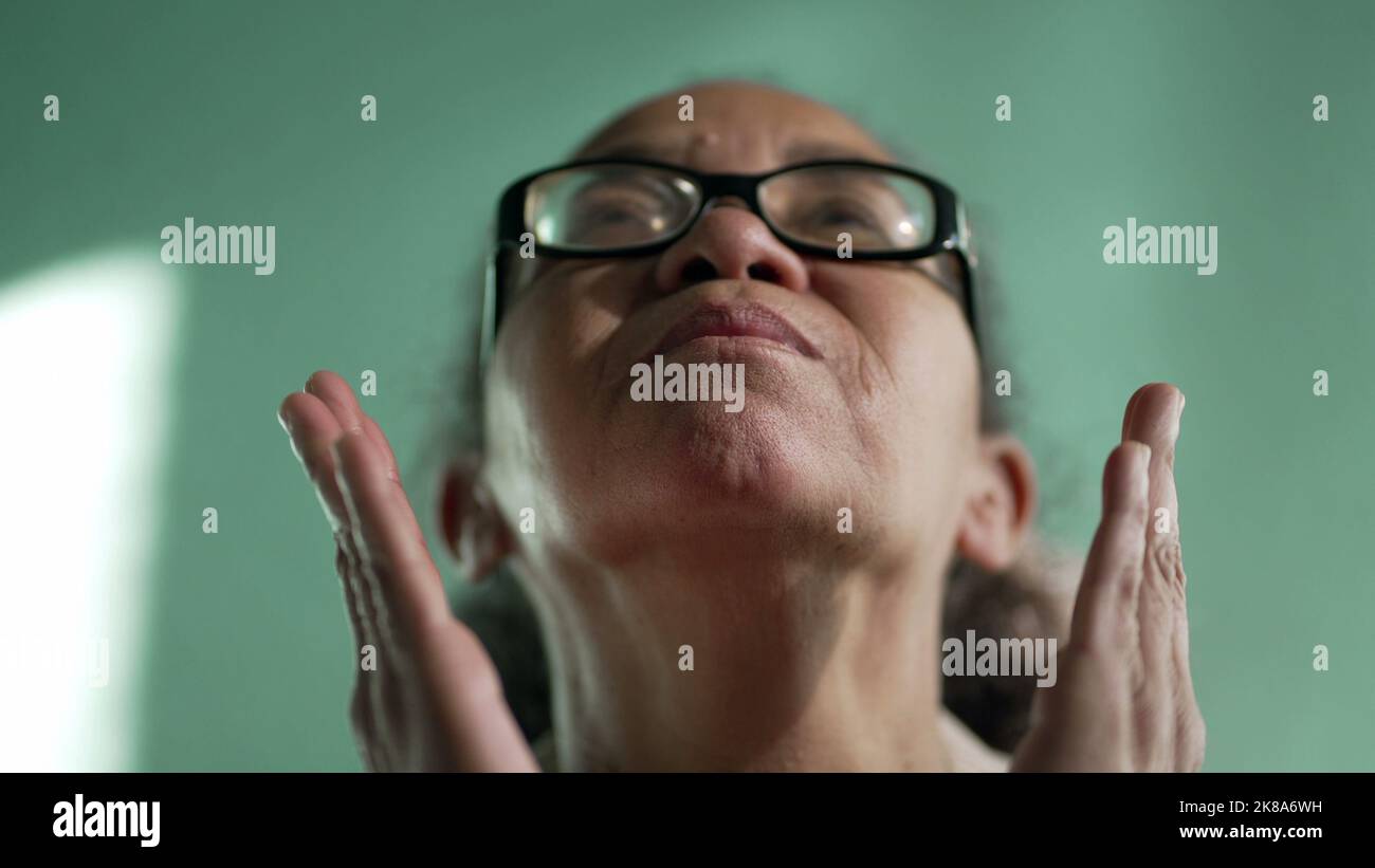 Religious older senior hispanic woman praying to God. Spiritual South ...