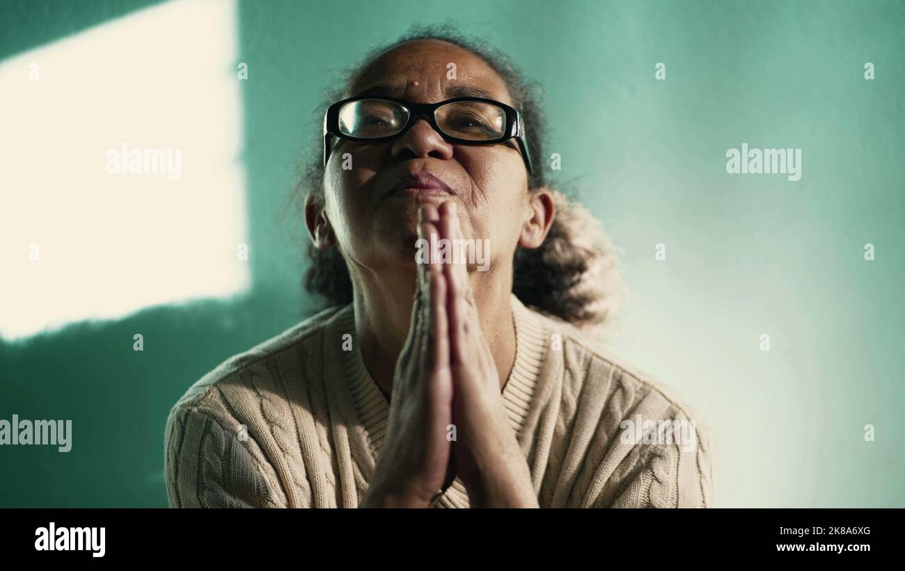 Religious hispanic older woman praying to God. South American senior ...