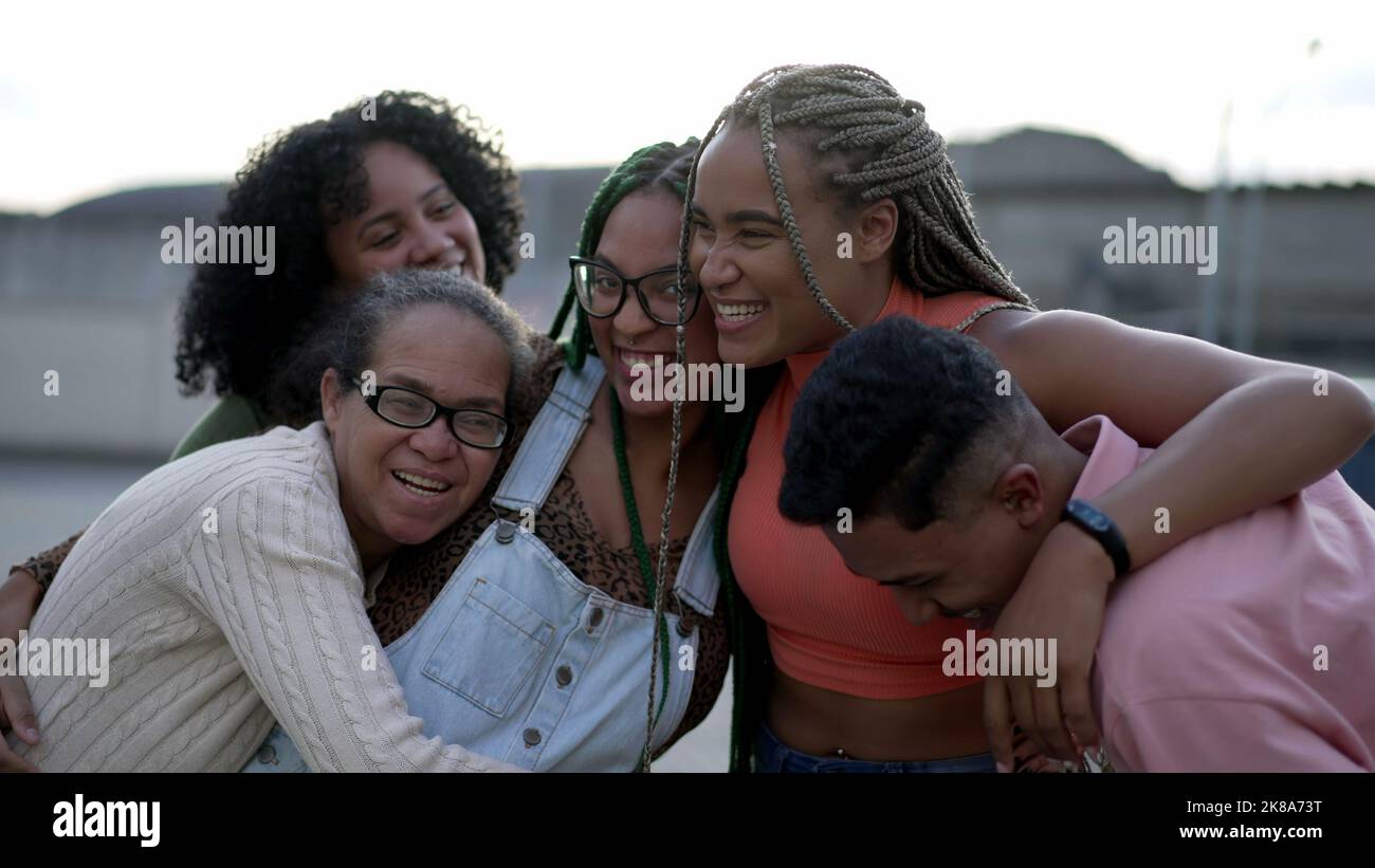 A black family embrace. Group of South American hispanic people hugging ...