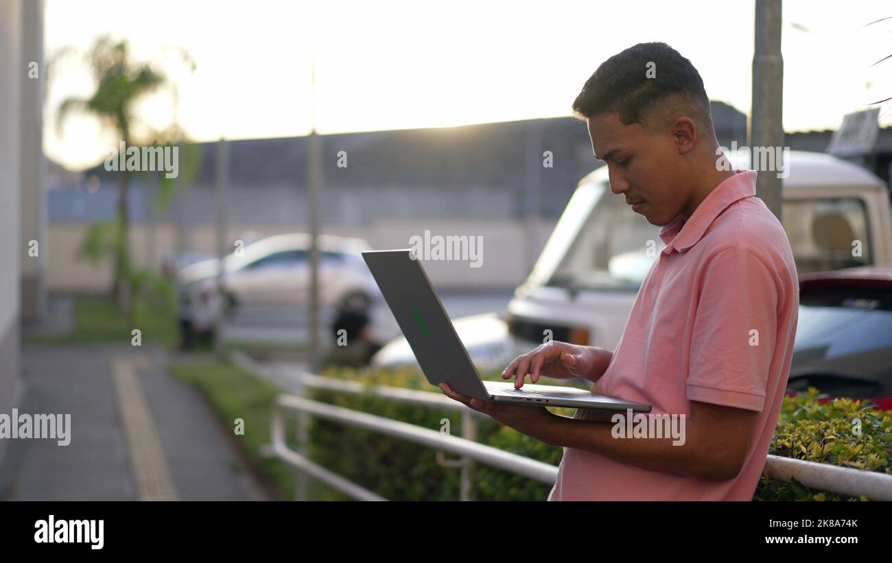 A hispanic young man turning computer ON. Person opening laptop sitting ...