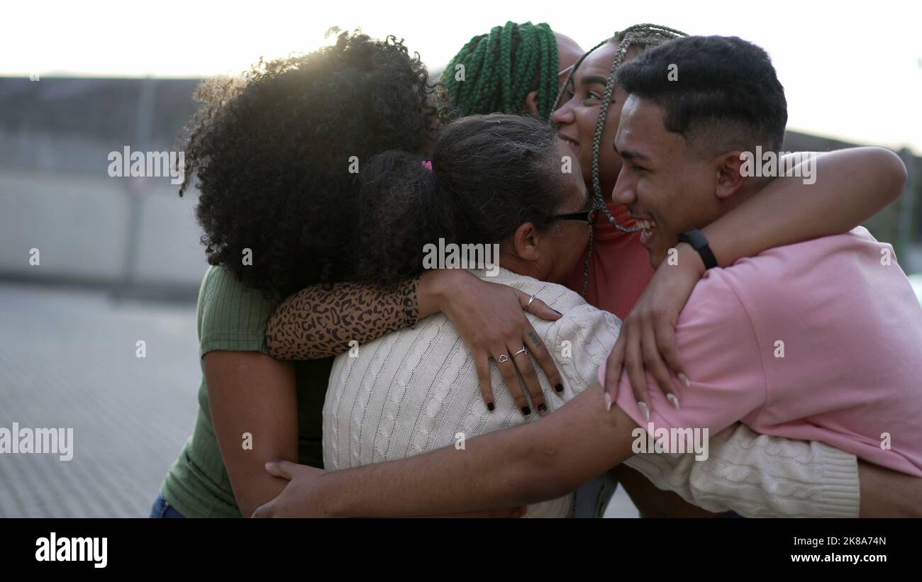 A black family embrace. Group of South American hispanic people hugging ...