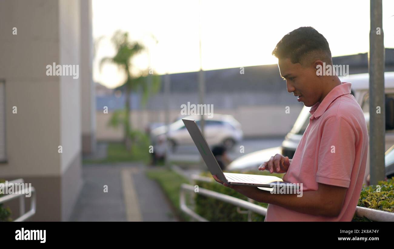 A hispanic young man turning computer ON. Person opening laptop sitting ...