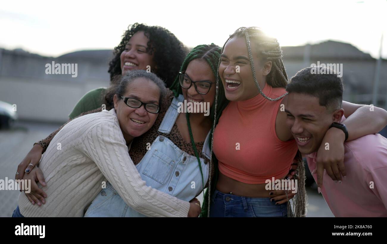 A black family embrace. Group of South American hispanic people hugging ...