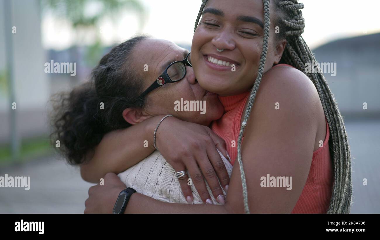 Brazilian adult daughter hugging senior mother showing love and ...