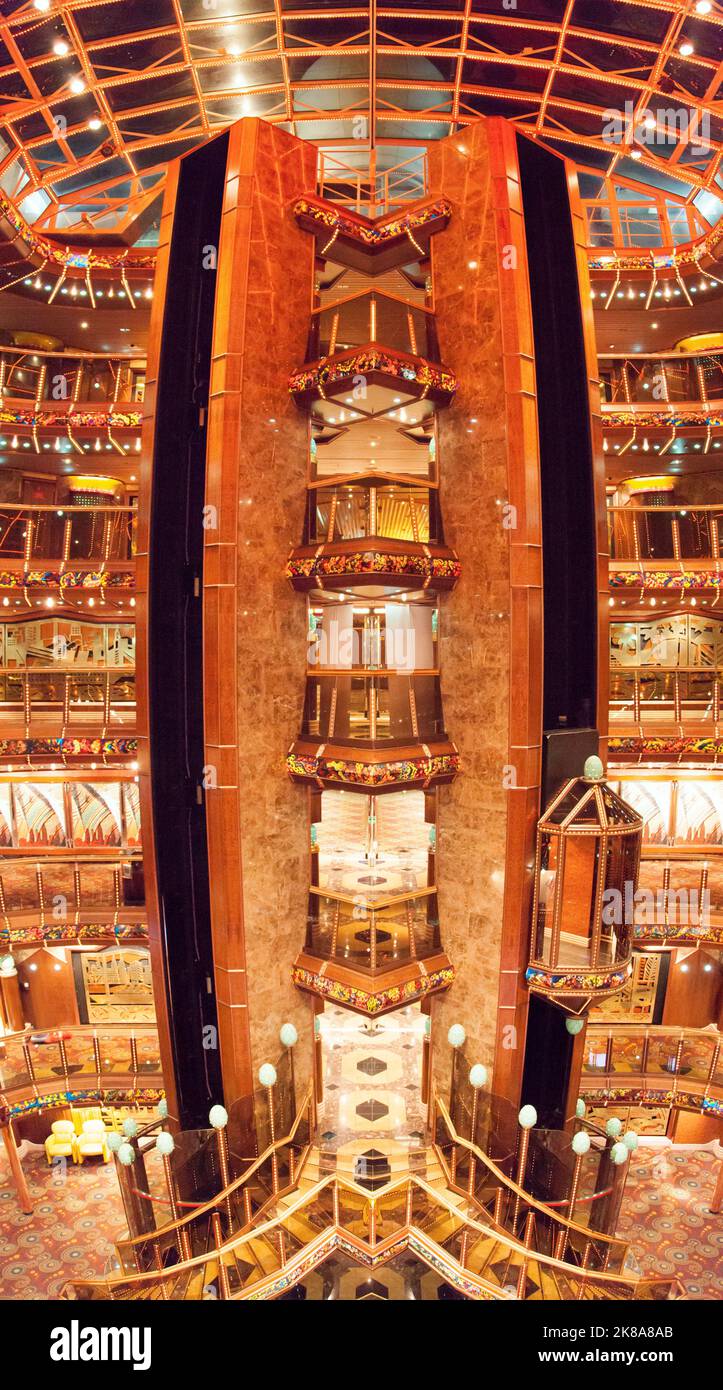 The vertical panoramic view of a colorful cruise ship interior with a ...