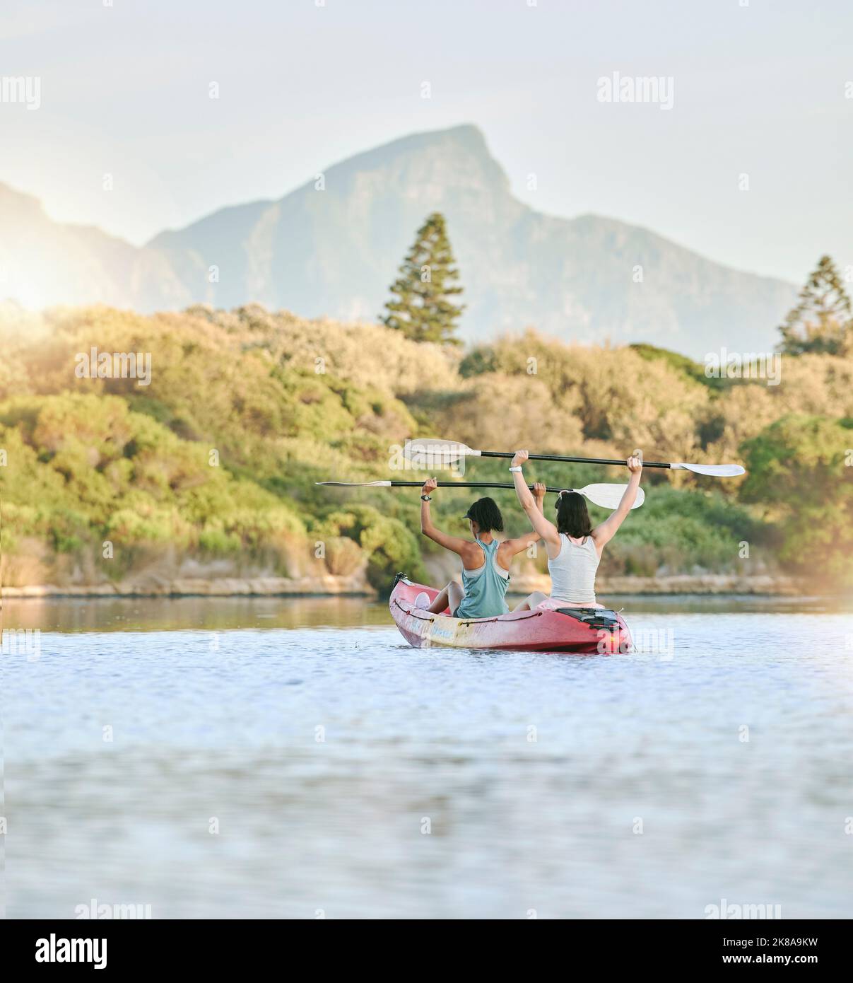 Woman friends, celebrate in kayak and lake exercise in a canoe together ...