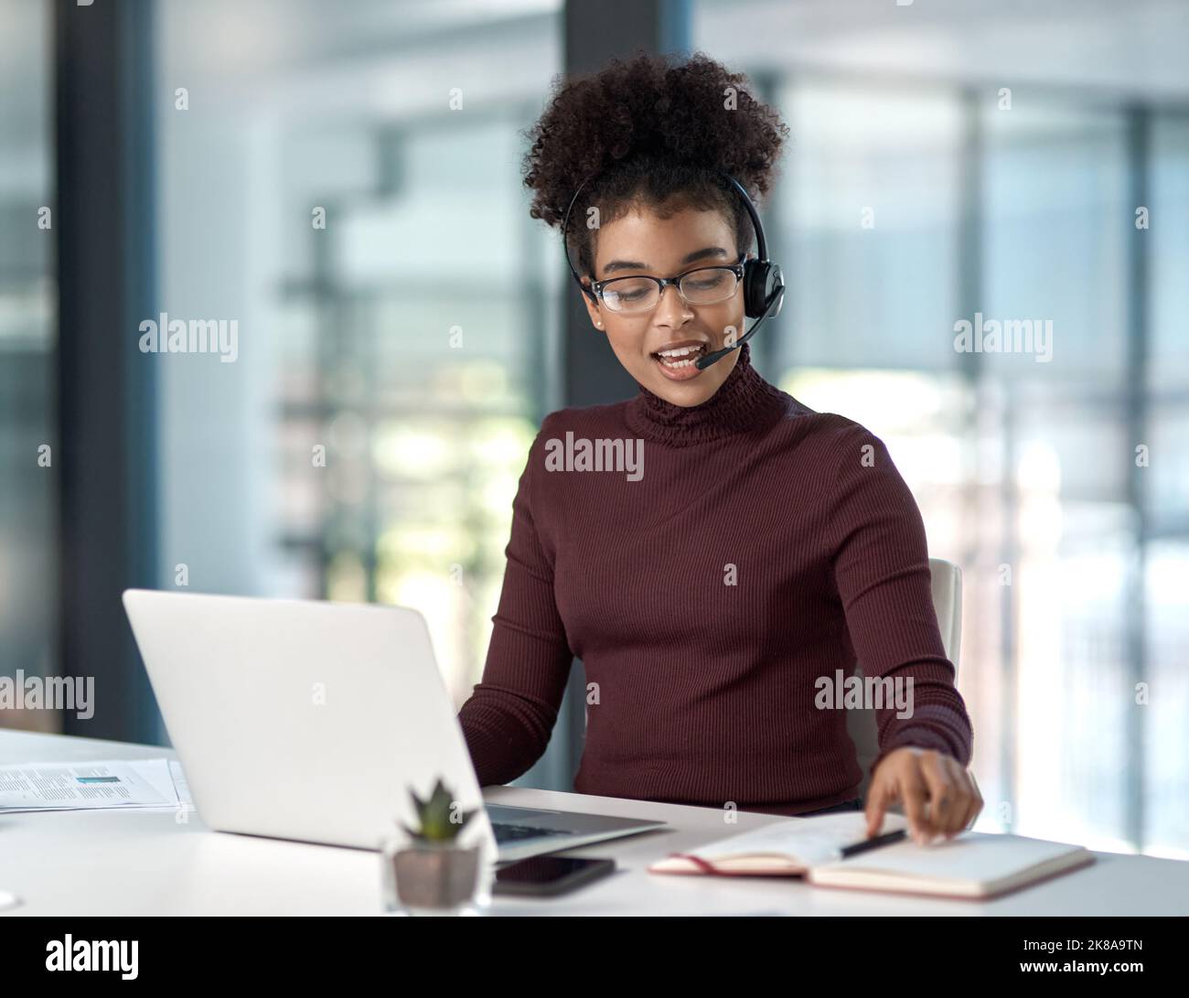 Talk the talk. a young female agent working in a call centre gesturing ...