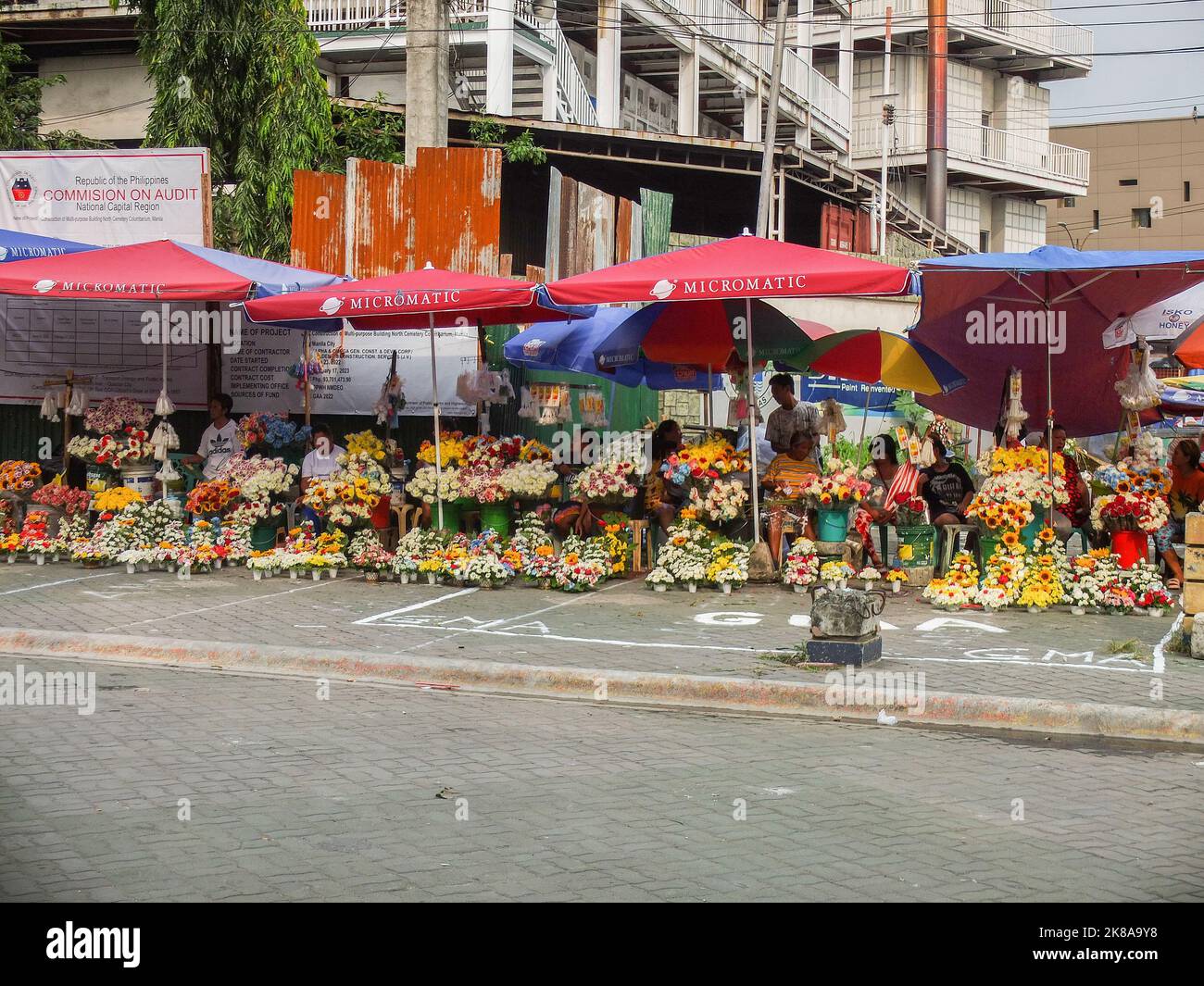 A long line of flower vendors stalls near the Manila North Cemetery's ...