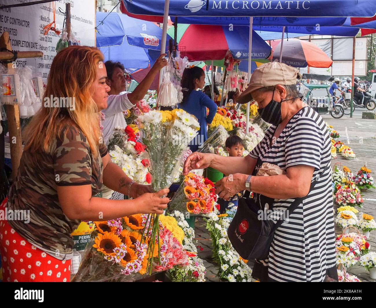 A flower vendor outside Manila North Cemetery entrance gate attends to ...