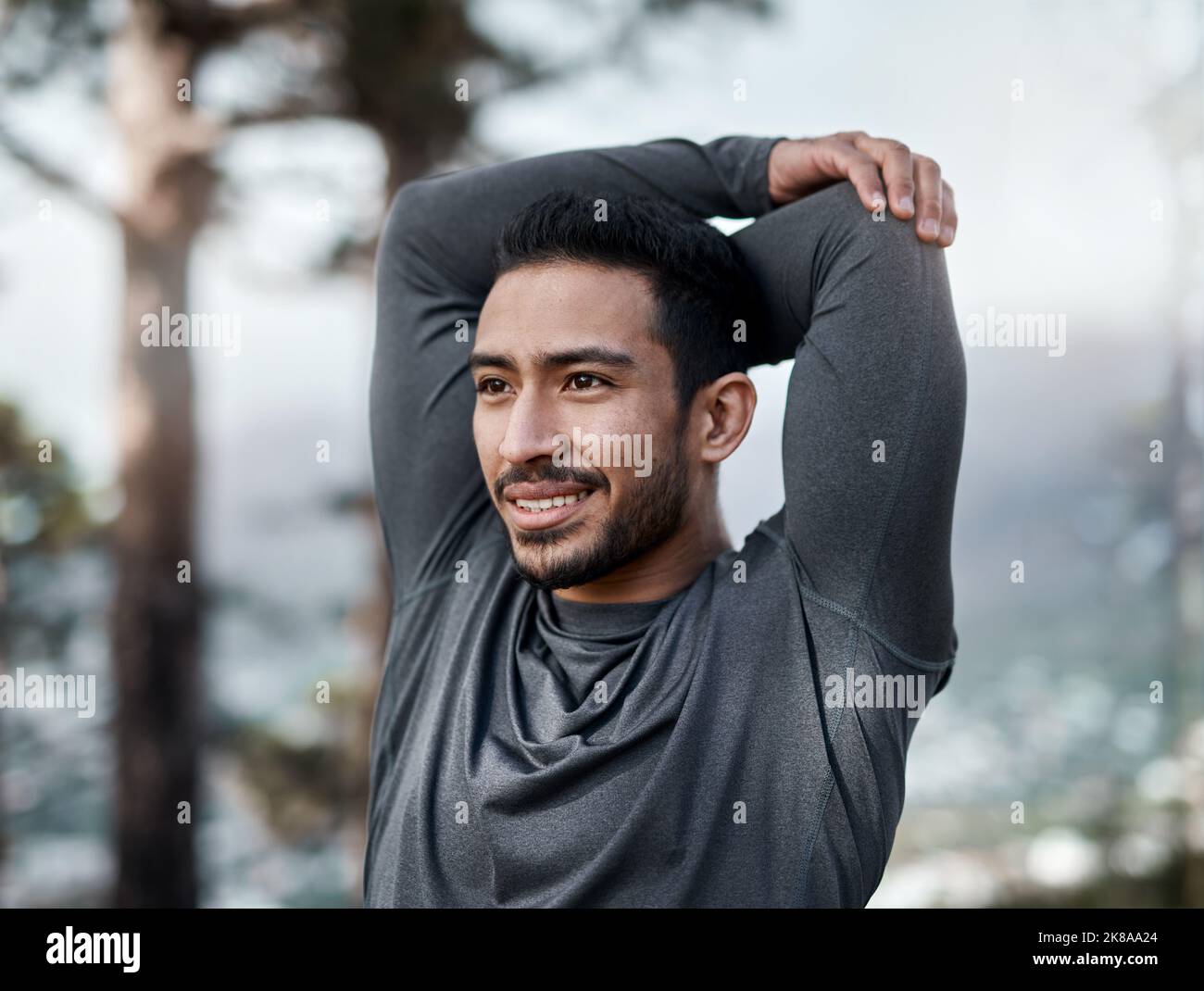 Stretch all your muscles before exercising. a handsome young man stretching before exercising ...