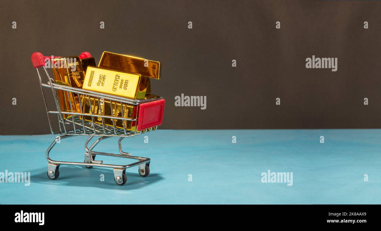 Shopping cart full of pure shiny gold bar or ingot on clean banner ...