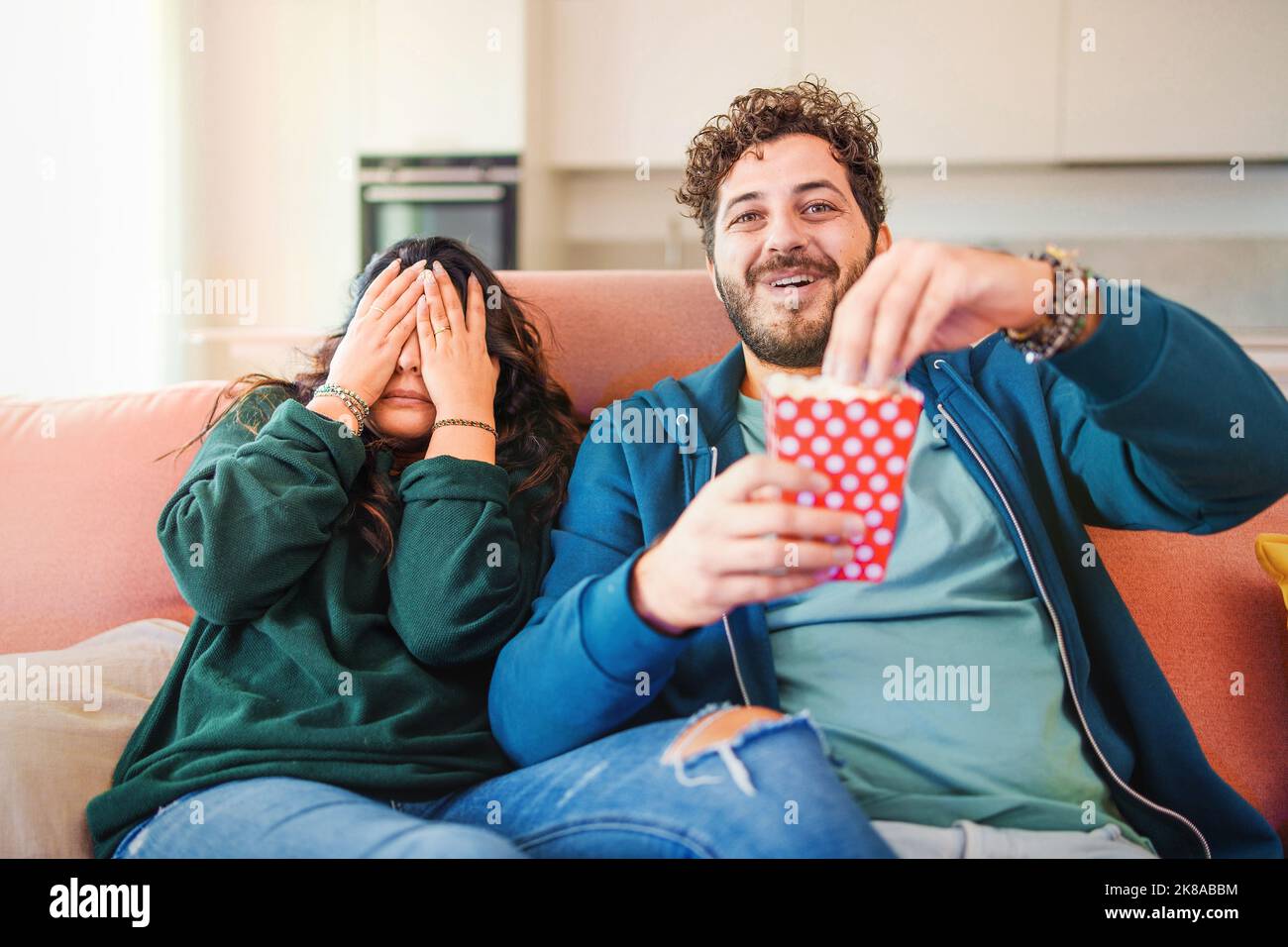 Scared millennial newlywed couple watching horror movie on tv ...