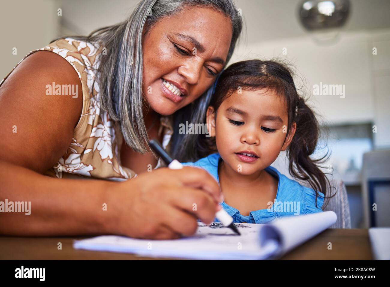 Girl homework, learning and grandmother helping child with school education in a notebook in ...