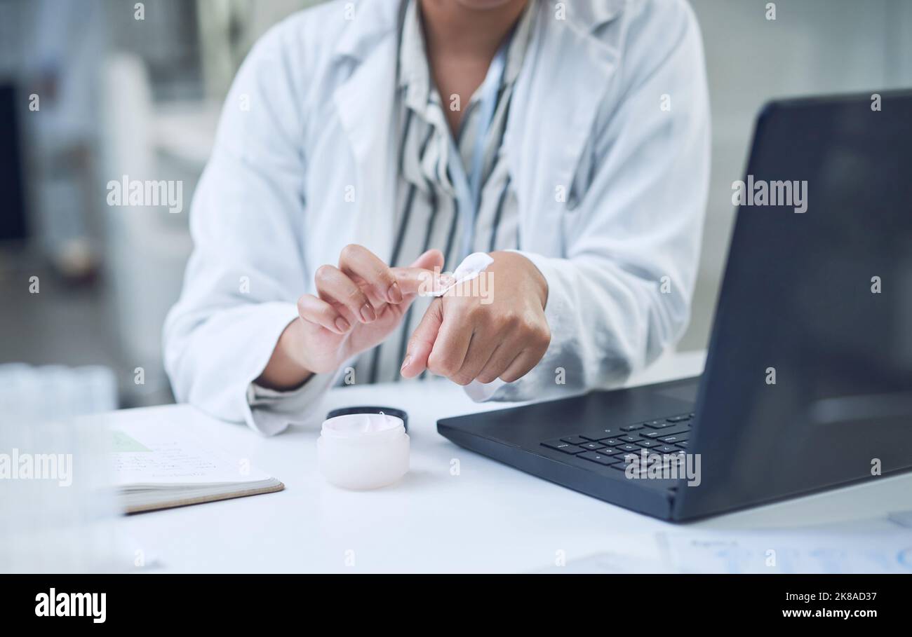 Before we launch, we need to test. a scientist applying hand cream ...
