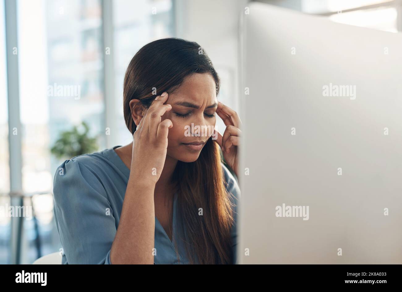 My head is about to explode. a young businesswoman experiencing a ...