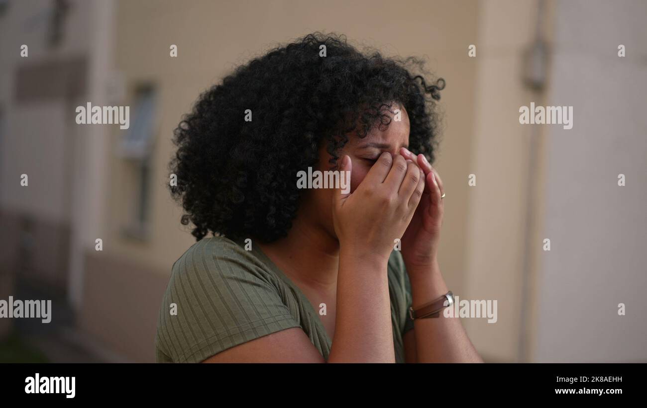 One crying young black woman covering face in despair. Tearful sad ...