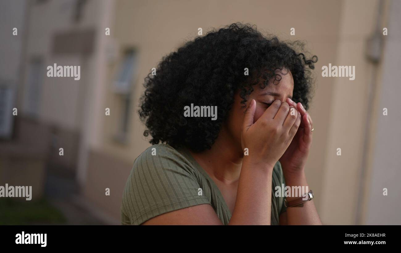 One crying young black woman covering face in despair. Tearful sad ...