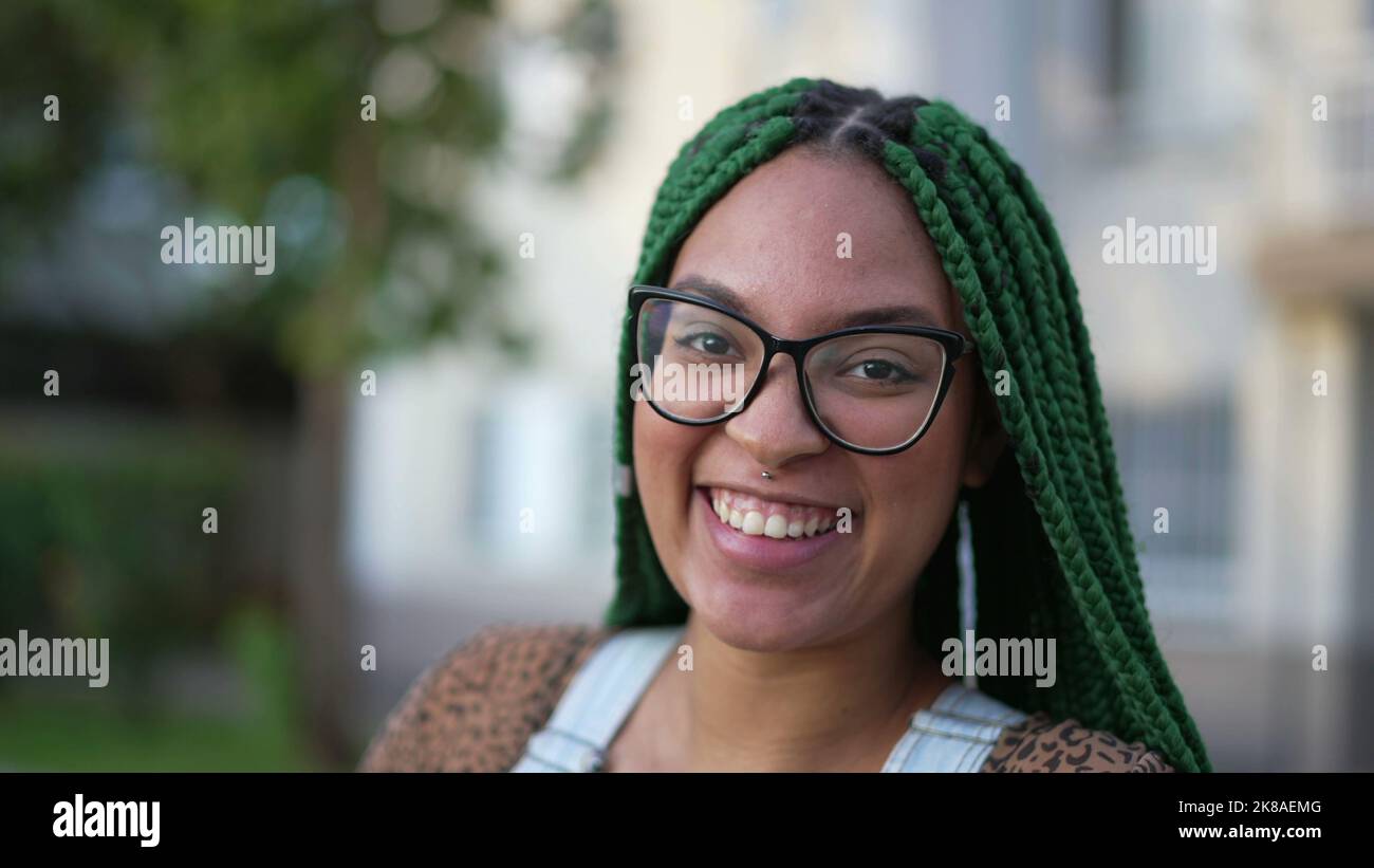 One happy young black woman with box braids hairstyle standing outside ...