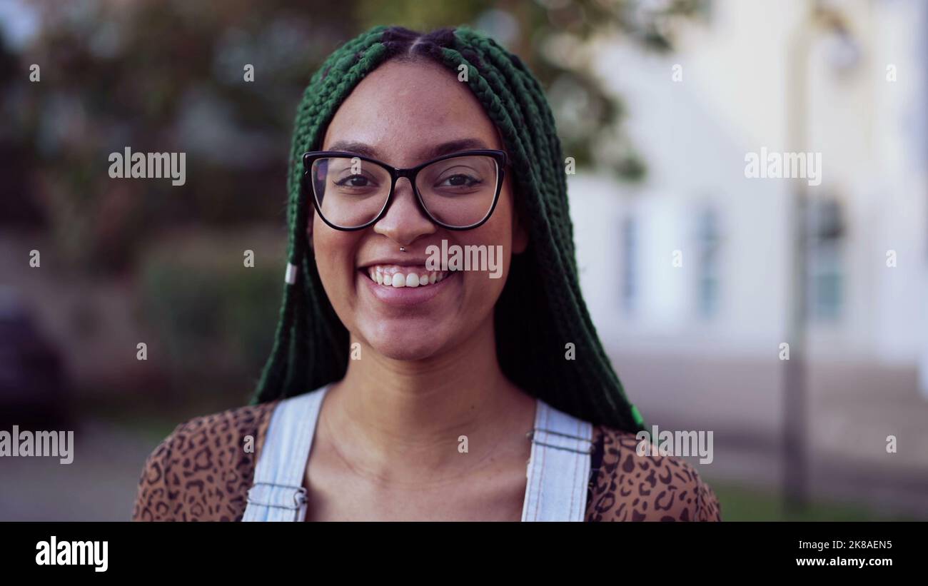 One happy young millennial black woman standing outdoors smiling at ...