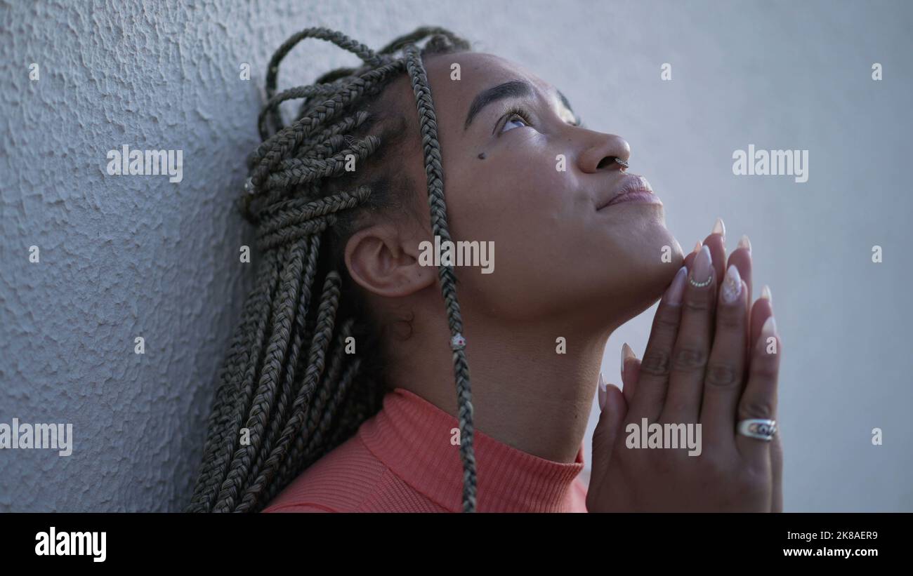 One spiritual young black woman praying to God pleading help and ...