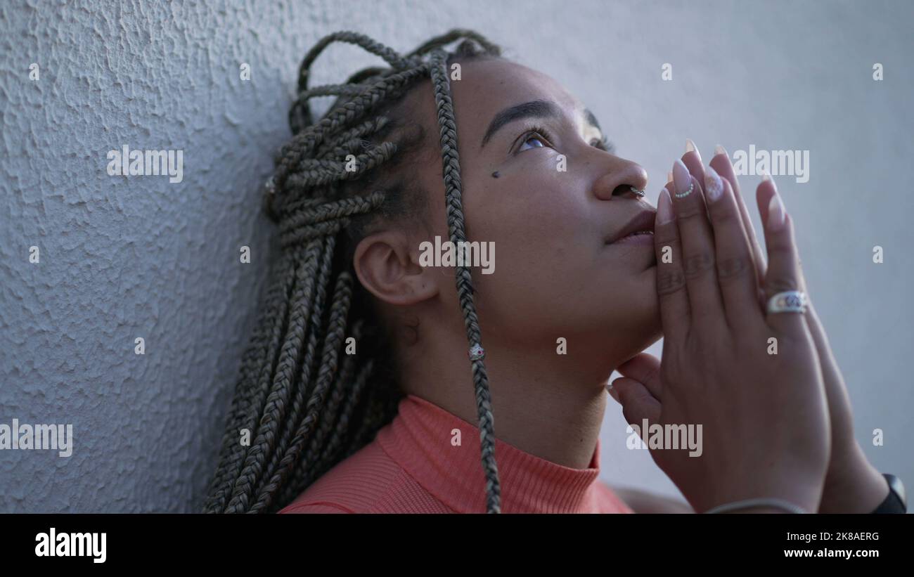 One spiritual young black woman praying to God pleading help and ...