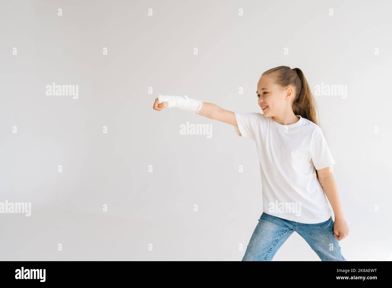 Side view of joyful sweet little girl with broken hand wrapped in white ...