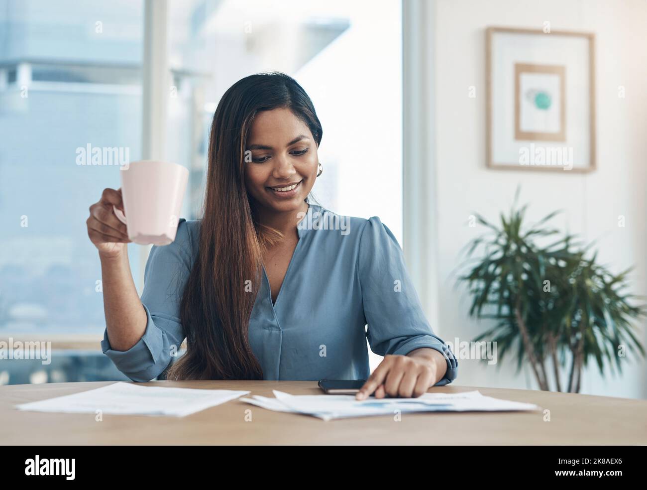 Taking note of her forthcoming plans. a young businesswoman drinking ...