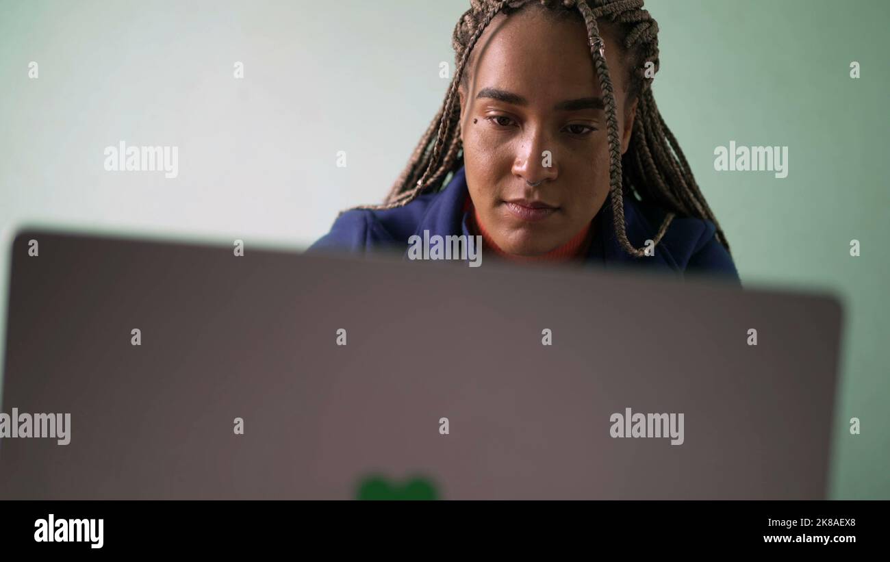 One young black woman opening laptop screen. A Brazilian latin female ...