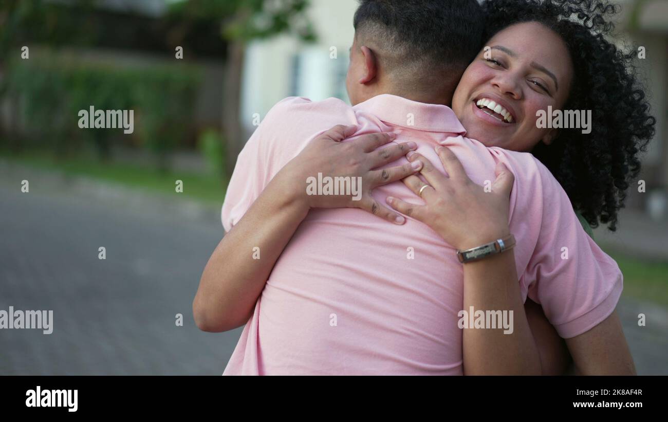 Two happy people embracing celebrating reunion. Young woman hugging ...