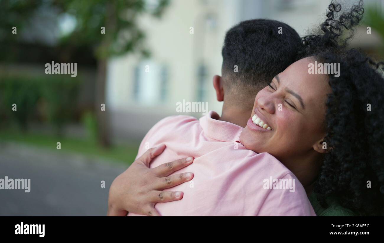 Two happy people embracing celebrating reunion. Young woman hugging ...