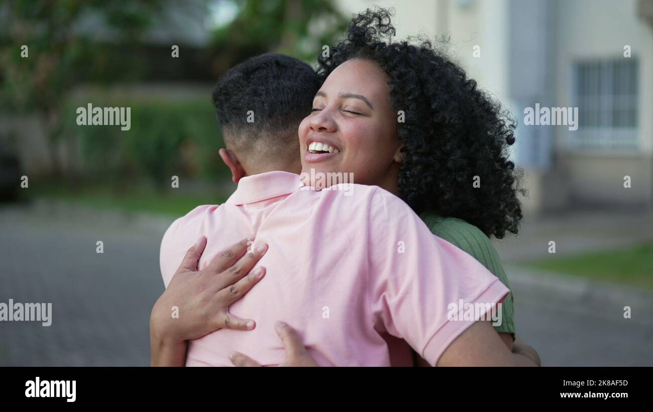 Two happy people embracing celebrating reunion. Young woman hugging ...