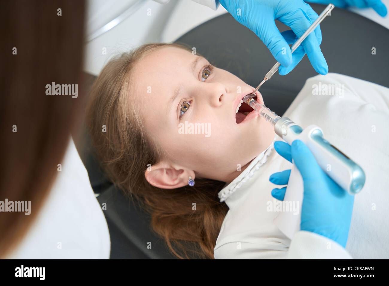 Pediatric dentist administering local anesthesia to little girl Stock ...