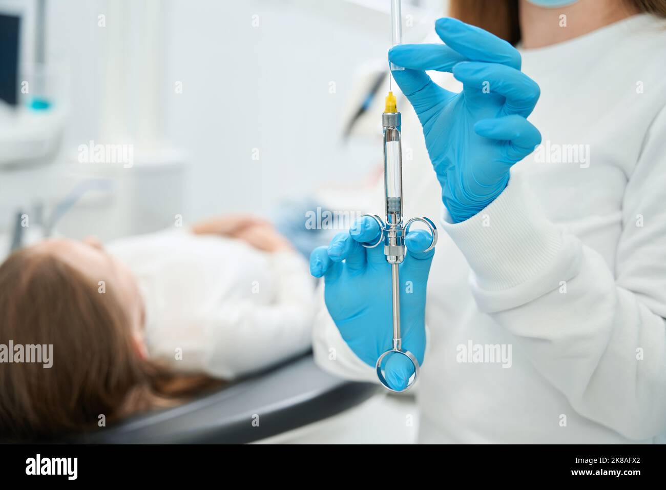 Dentist preparing to administer local anesthetic to patient Stock Photo ...