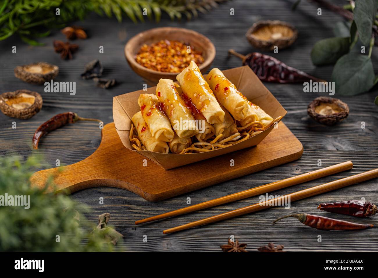Fried Chinese spring rolls with noodles served on take away plate Stock ...