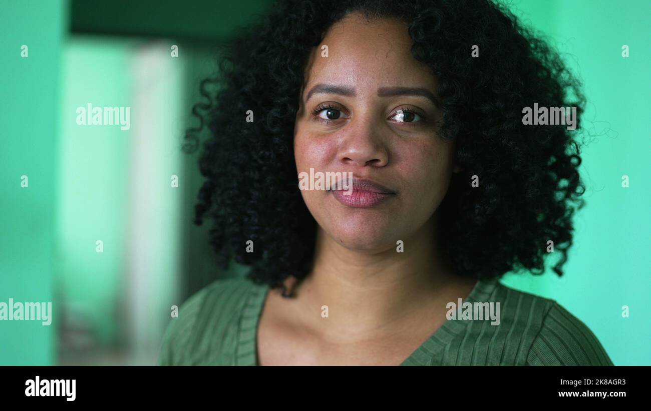 Portrait of a hispanic black latina woman with curly hair looking at ...
