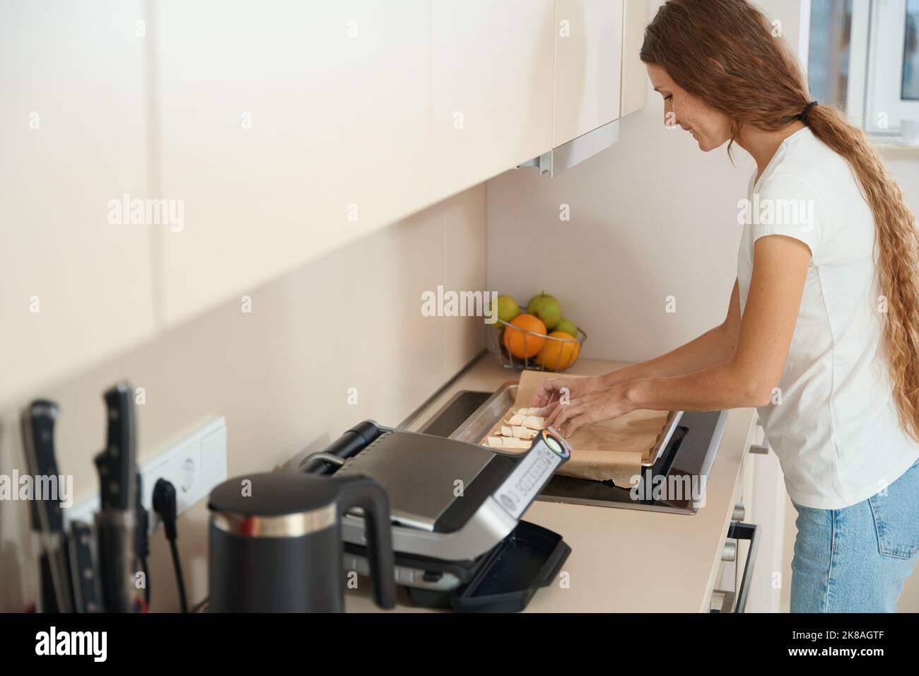Woman lays out piece of parchment dough on baking sheet Stock Photo - Alamy