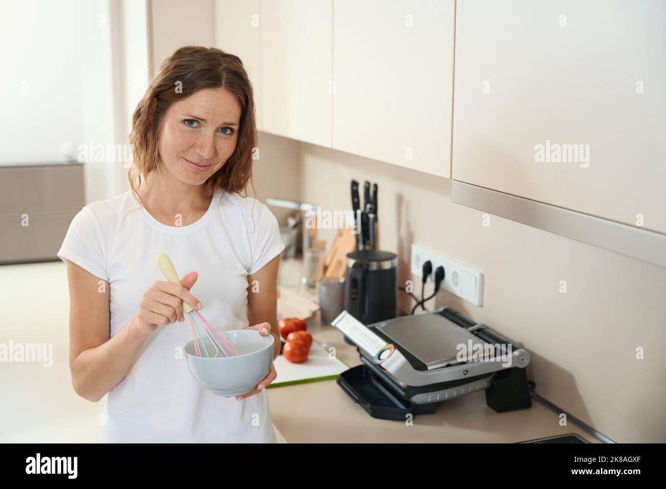 Woman is mixing ingredients for cooking in a deep bowl Stock Photo - Alamy