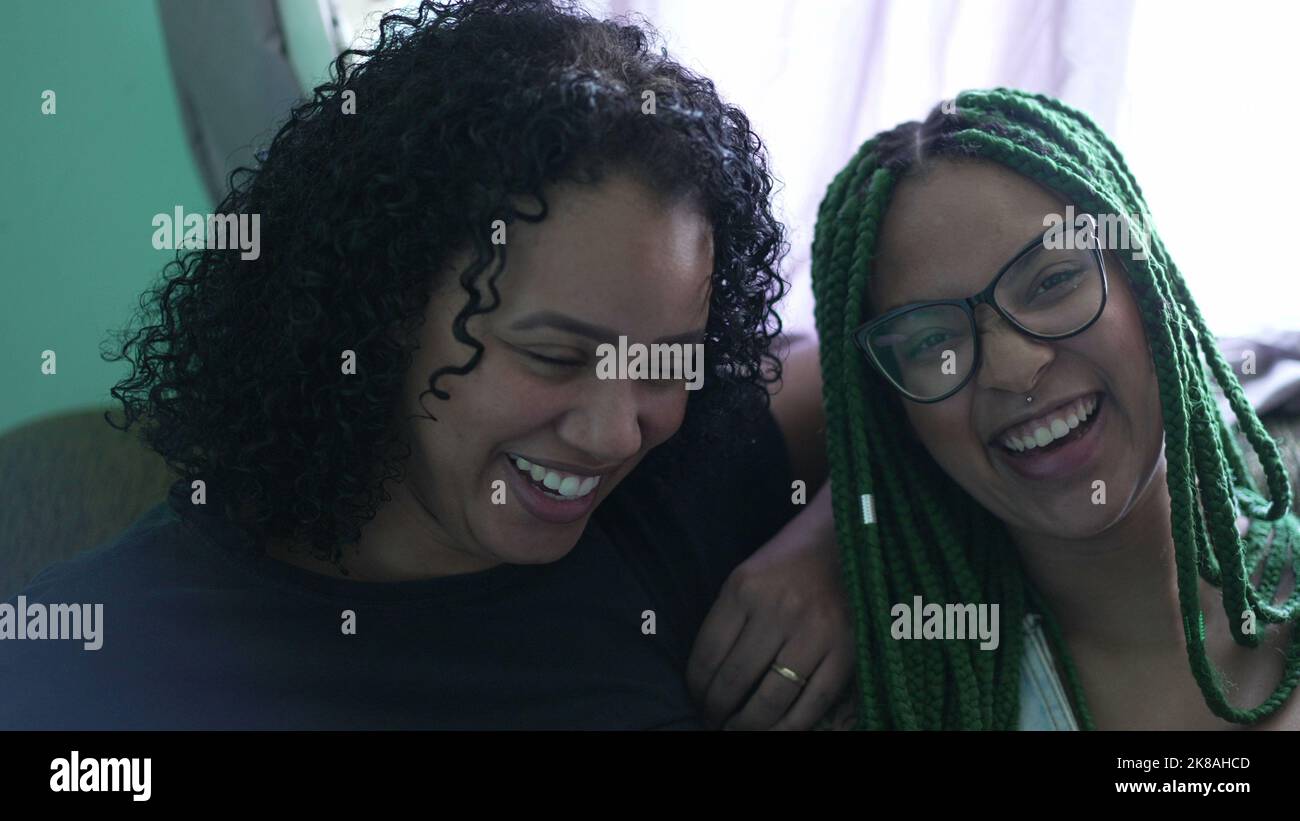 Two young black women laughing together. Hispanic latin women real life ...