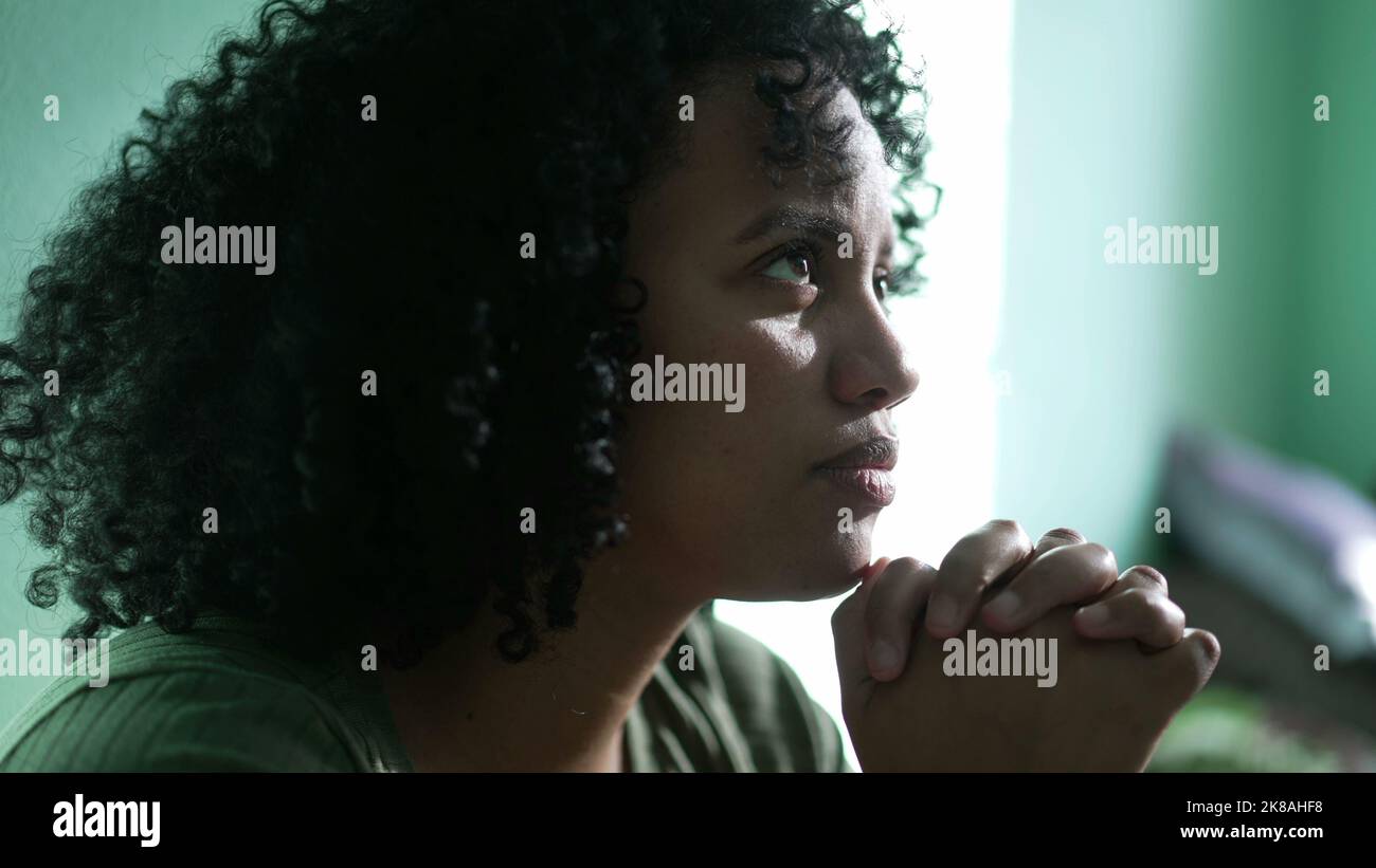 A spiritual African Woman opening eyes to sky in prayer having HOPE ...