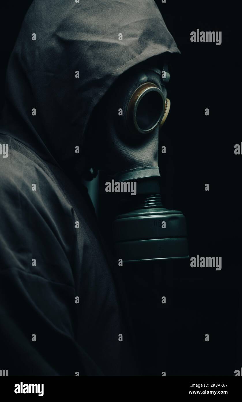 A scary man in a cloak wearing a gas mask. Dark background Stock Photo ...