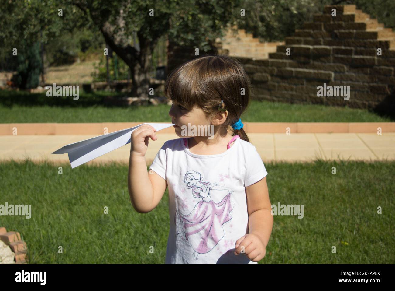 Picture of an adorable little girl playing a little paper airplane ...