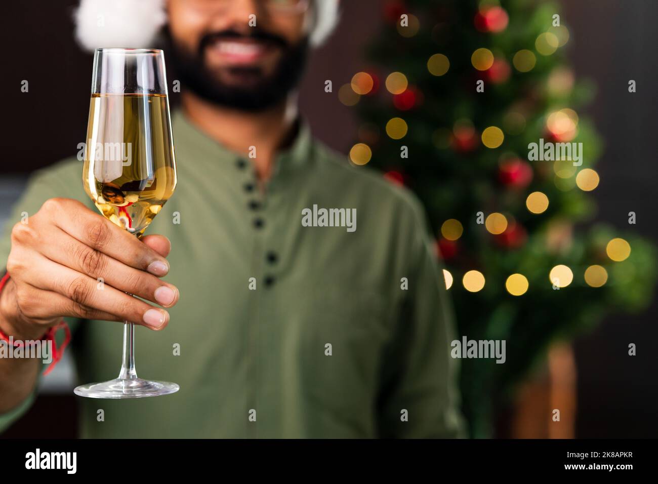 indian man drinking alcohol at home Christmas tree lights garland ...