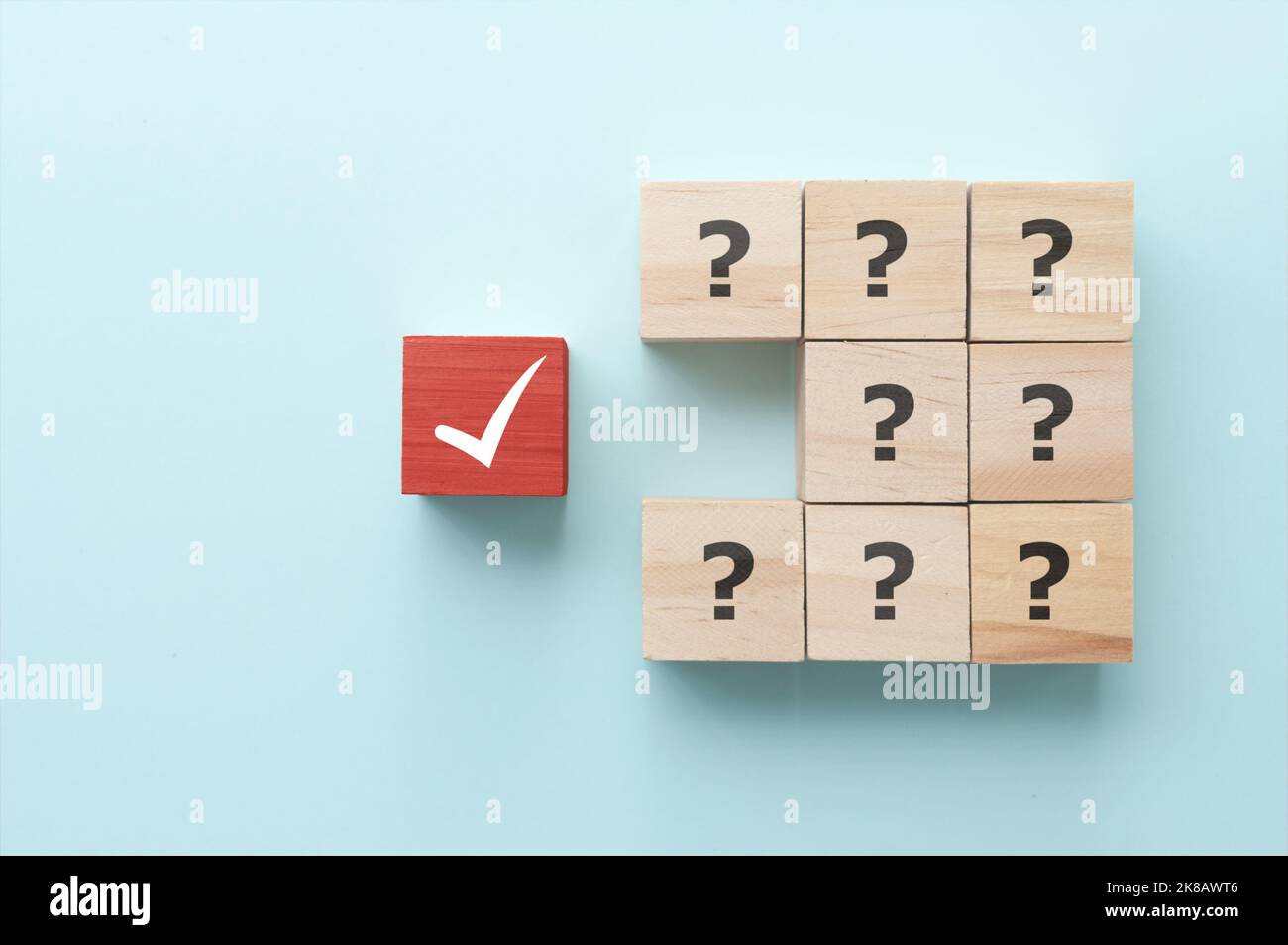 Red wooden block wtih tick standing out amongst question marks Stock ...