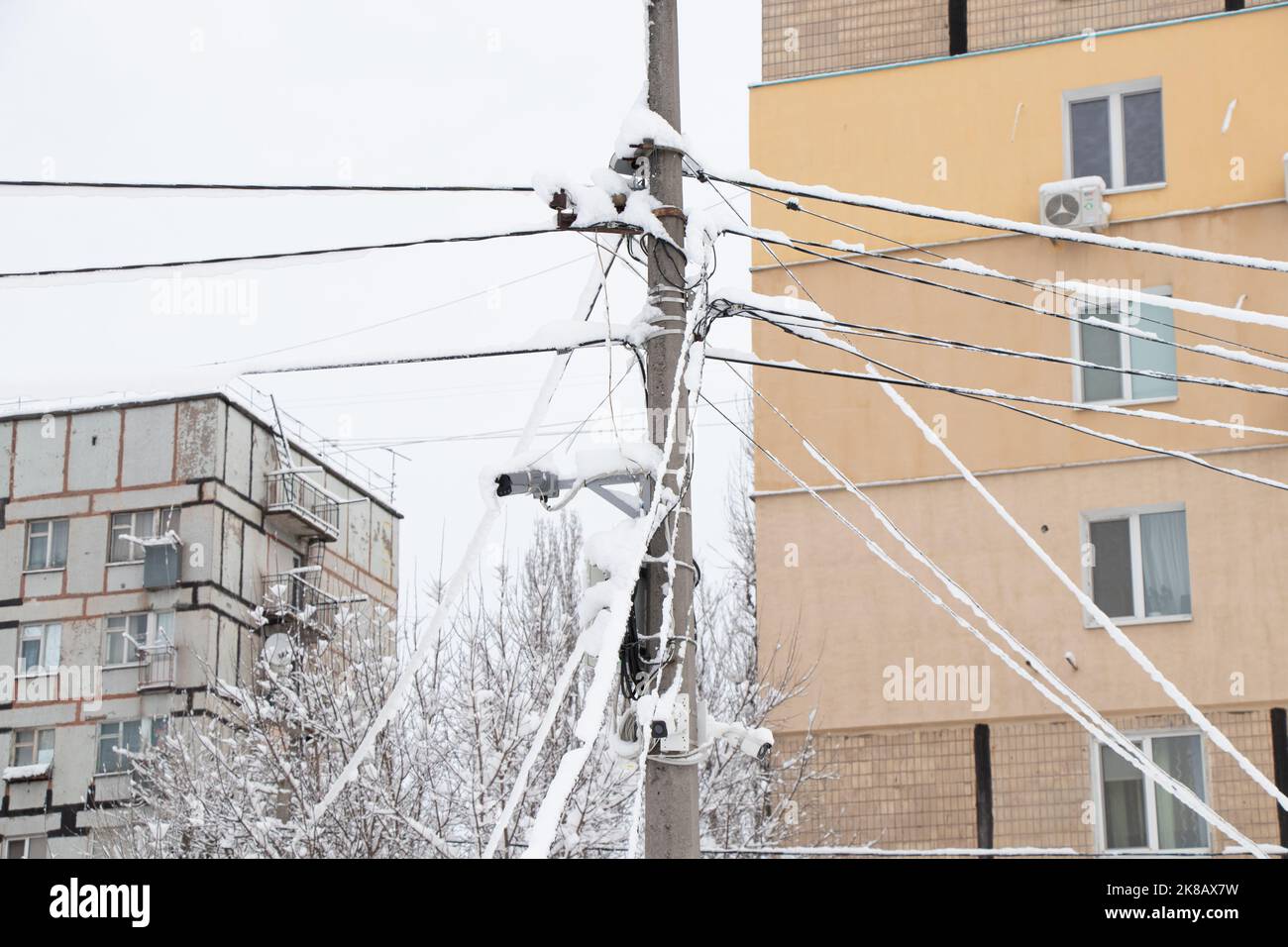 Electric wires in the snow with ice on a pole in a residential area of ...