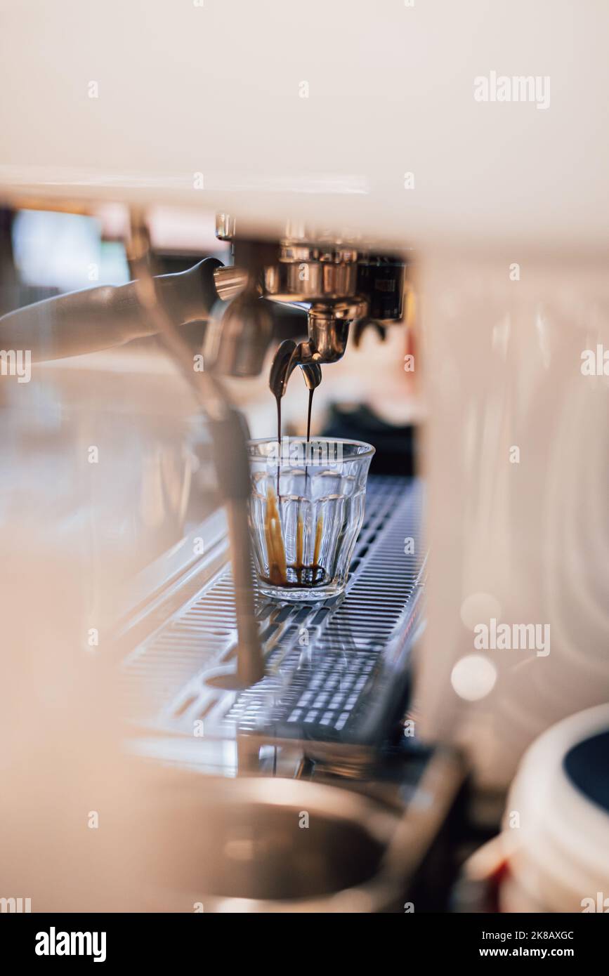 Coffee dripping in a transparent glass from a coffee machine Stock ...