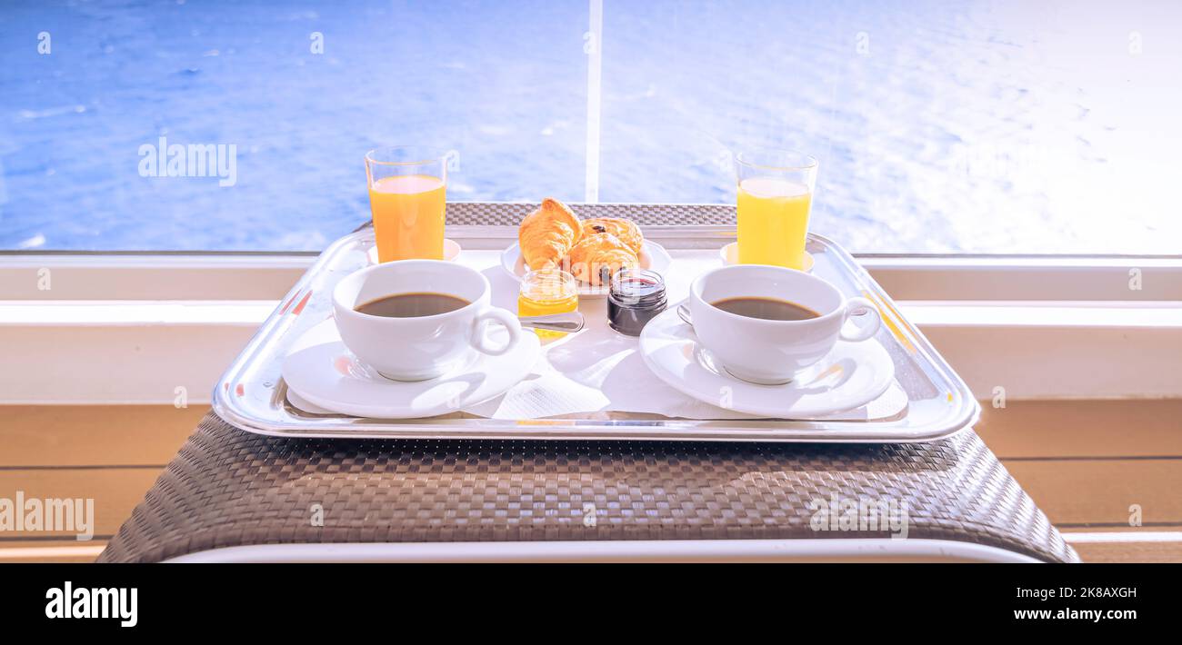Coffee cups and breakfast on the terrace of a balcony cabin of a cruise ...