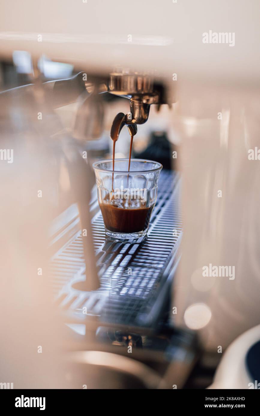 Coffee dripping in a transparent glass from a coffee machine Stock ...